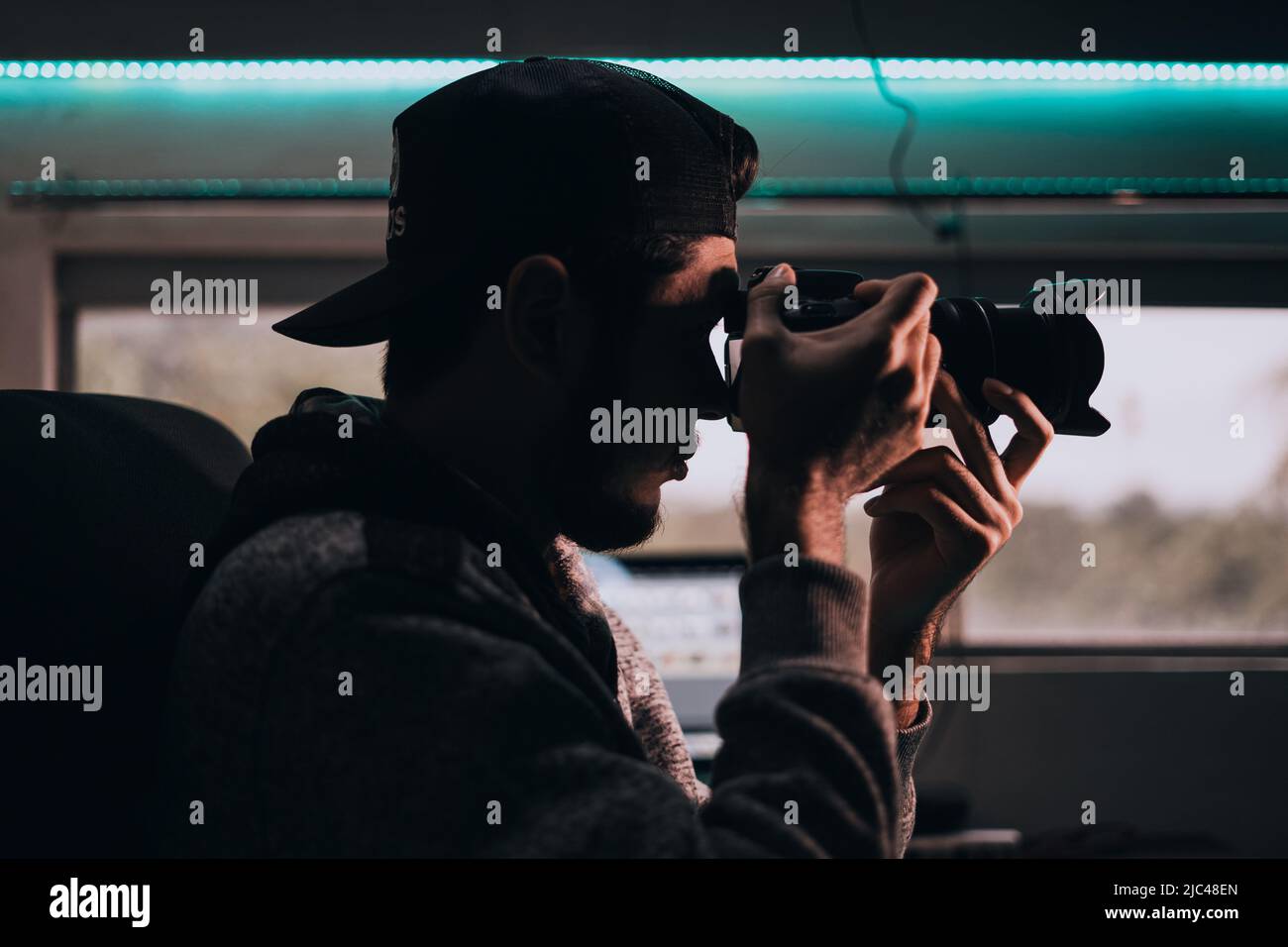 Profile of young man holding a photographic camera Stock Photo - Alamy