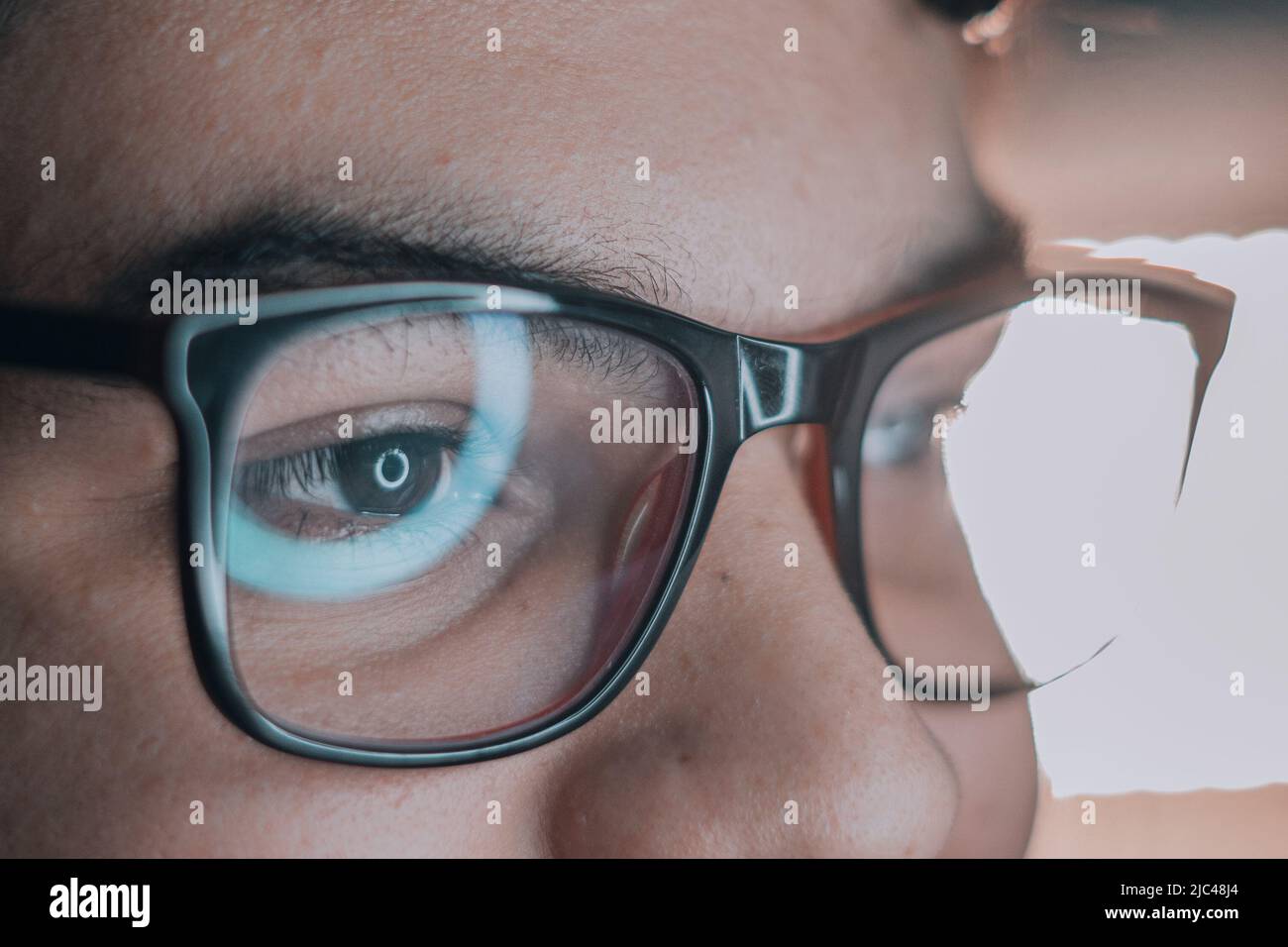Reflection of a computer screen on a young man's lens Stock Photo - Alamy