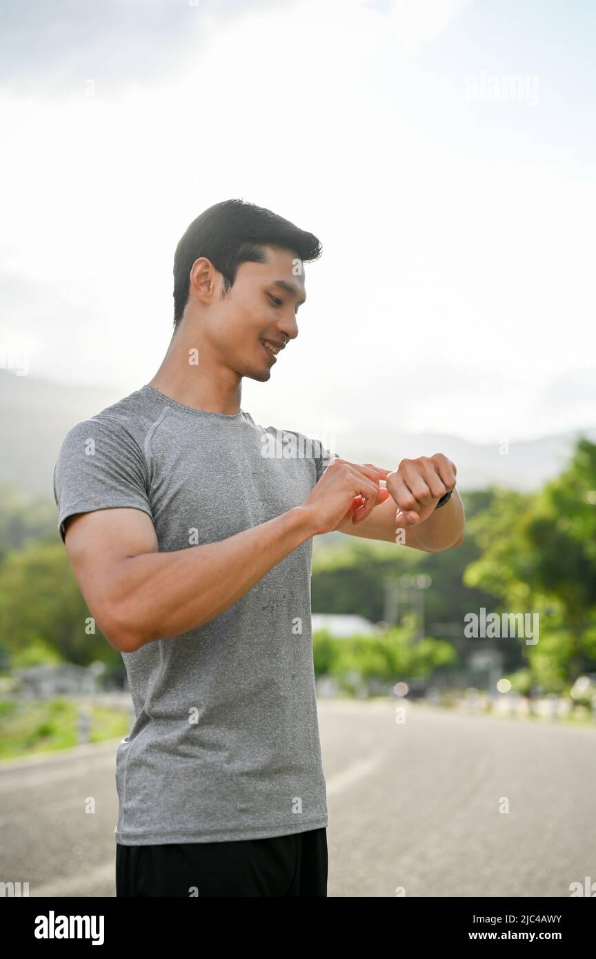Portrait of an active male athlete in a sportswear checking his pulse ...