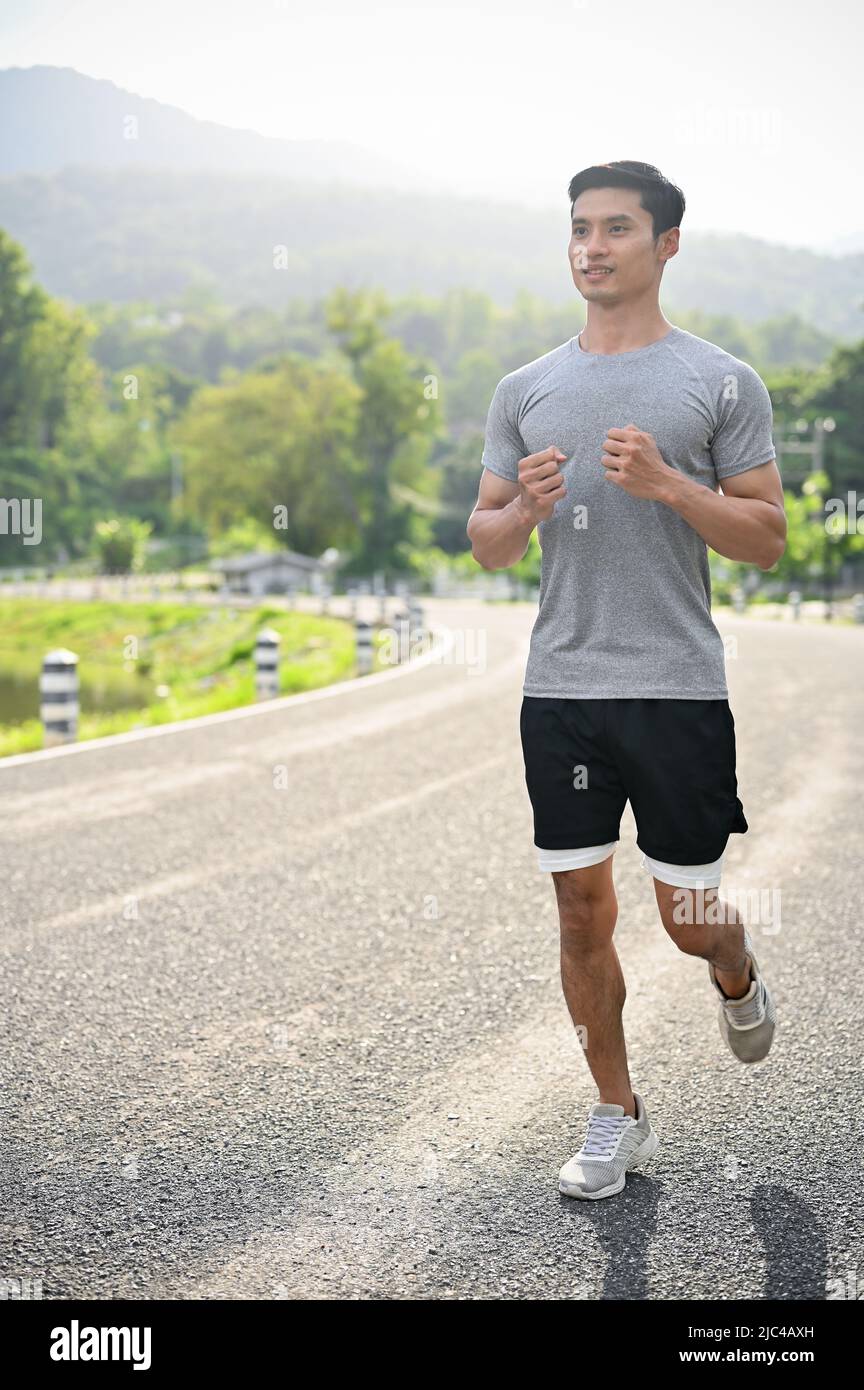 Portrait of an Asian male runner athlete in active sportswear running ...
