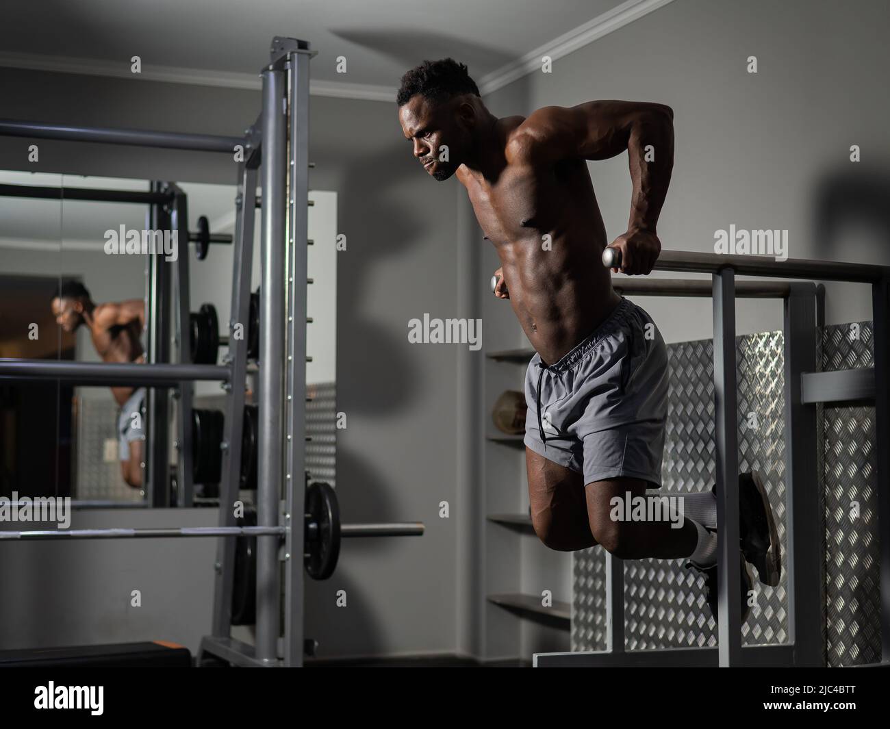 Handsome afro american man doing parallel bars exercise in gym Stock ...