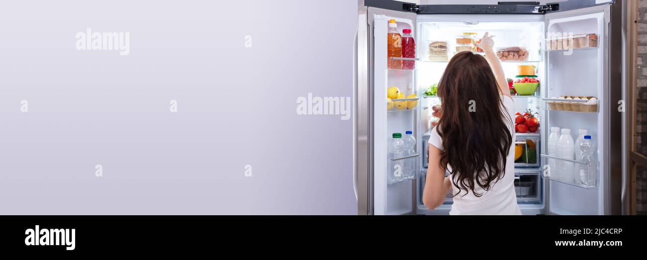 Rear View Of A Young Woman Taking Food To Eat From Refrigerator Stock ...