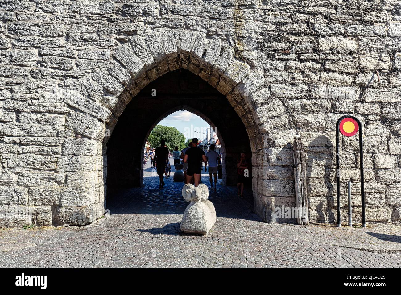 Gate in the city wall with stone sculpture, Gotland sheep as barrier ...
