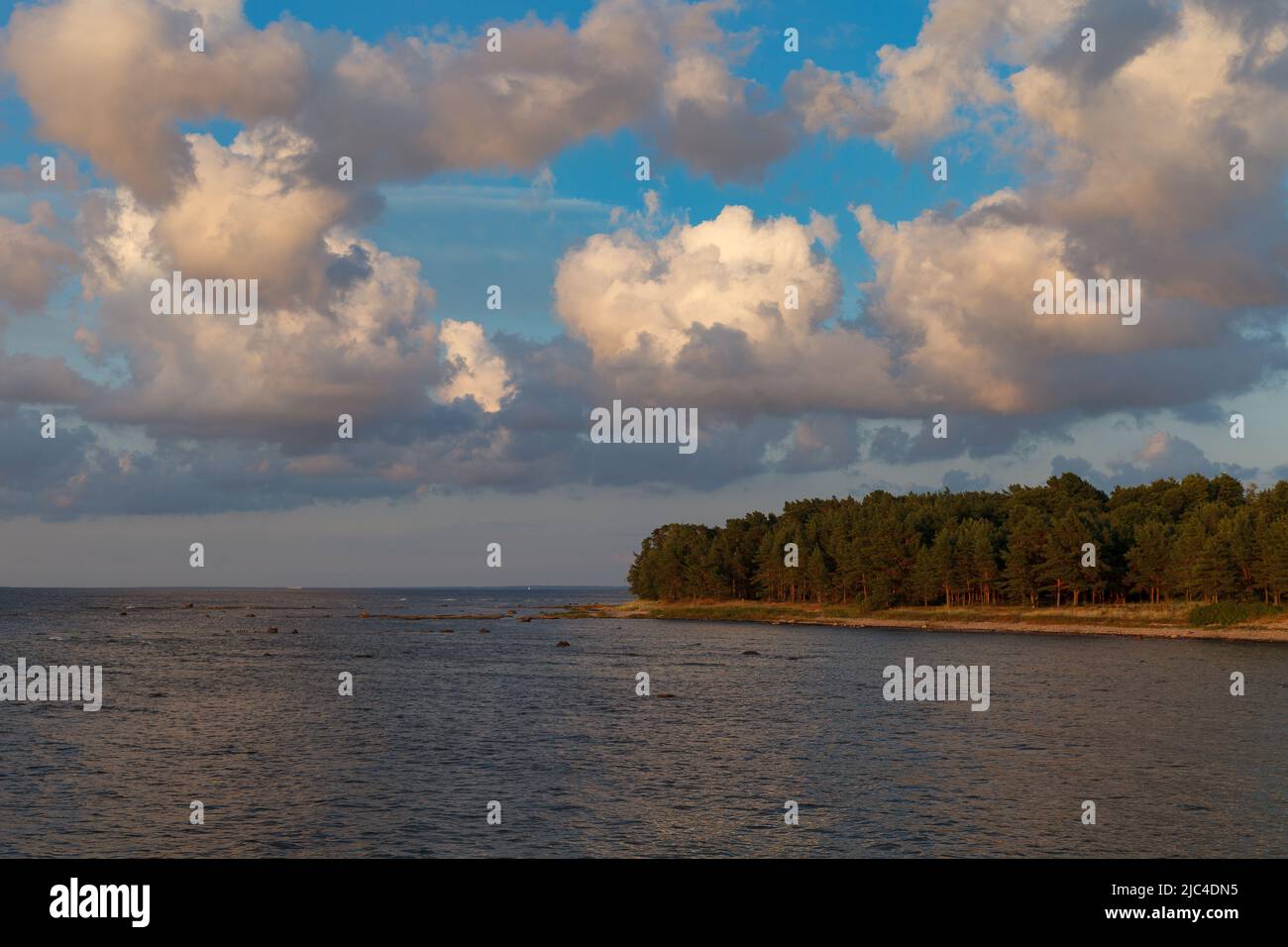 Sunset colored scenic view to the calm sea bay and tall cliff consist ...