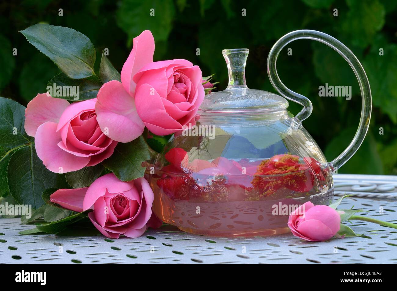 Rose tea in teapot and rose petals, tea Stock Photo - Alamy