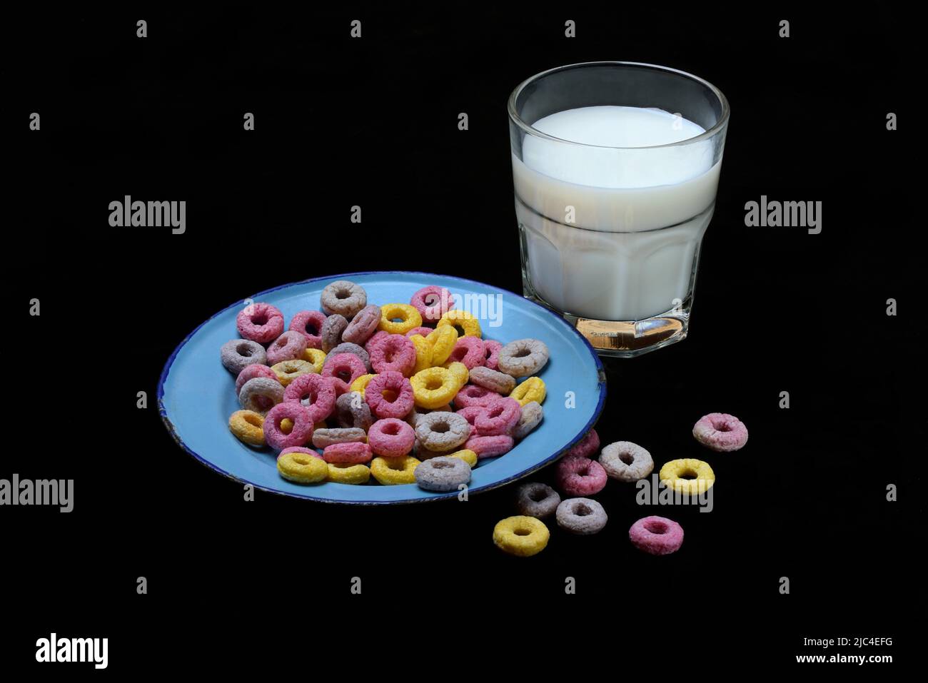 Fruit-flavoured cereal rings in plate and glass of milk, children's ...