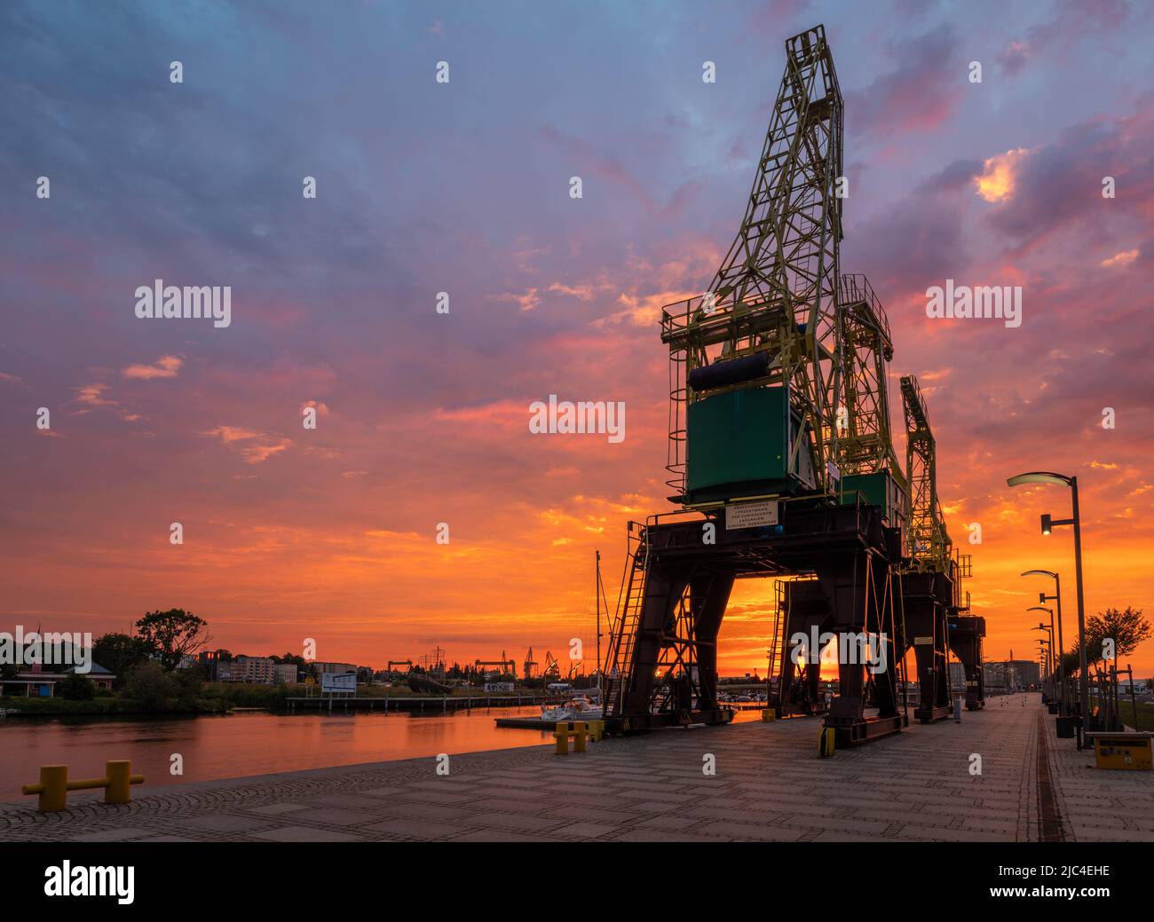 Historic harbour cranes on riverside boulevards in Szczecin during a ...