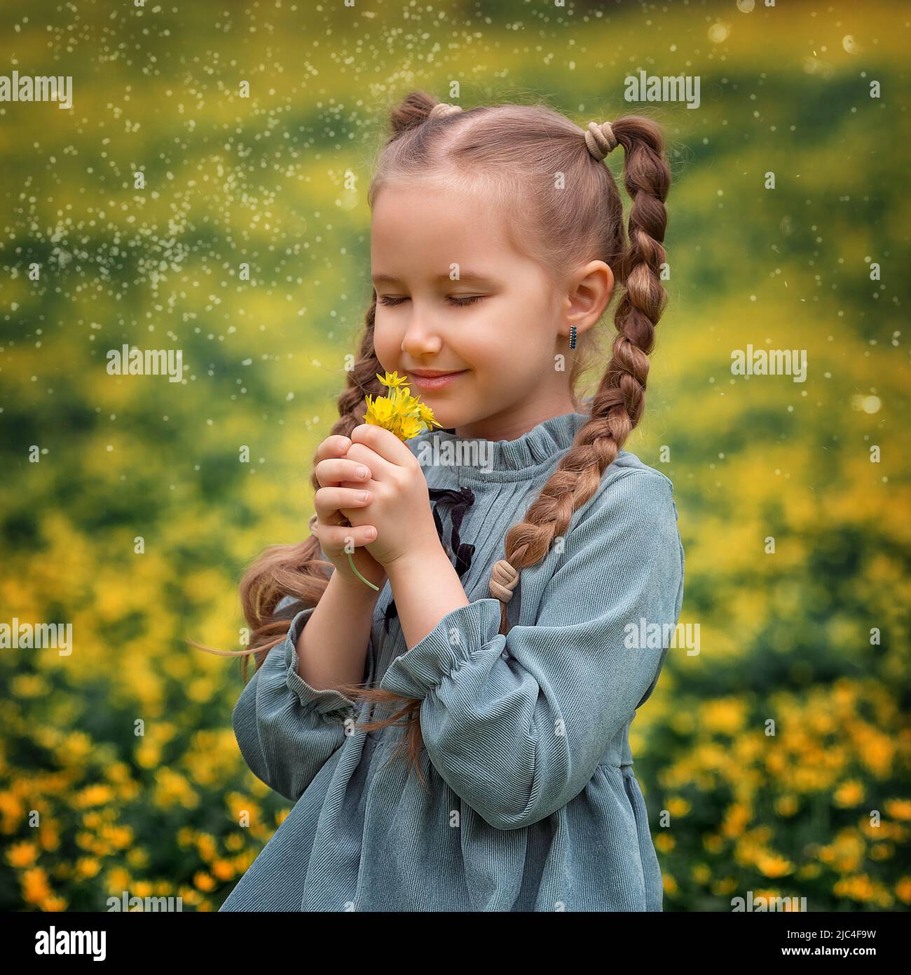 Portrait of a cute village girl kid with flower on a flower field. A ...