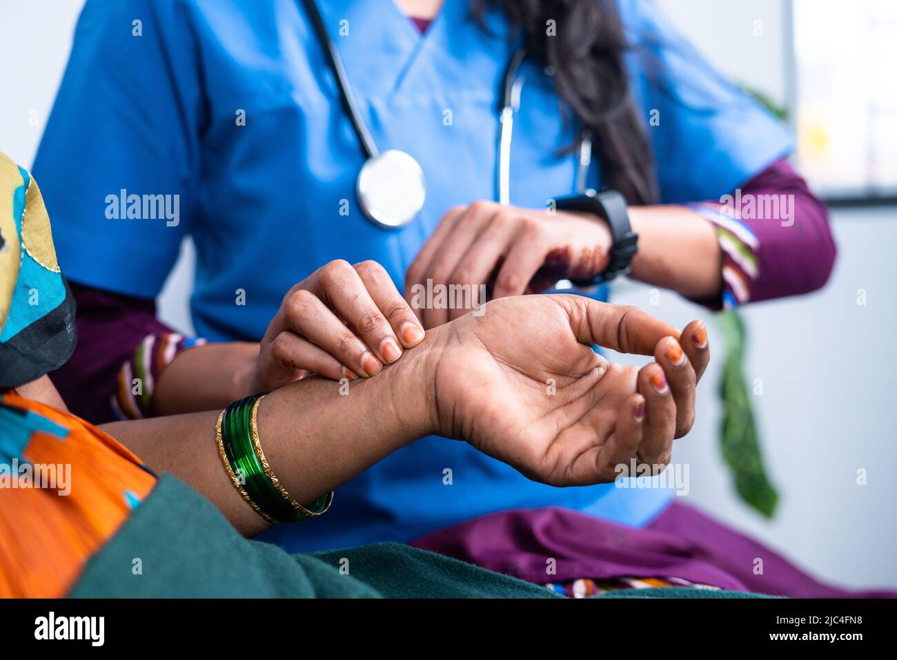 close up shot of doctor counting pulse by holding hand of sick patient ...