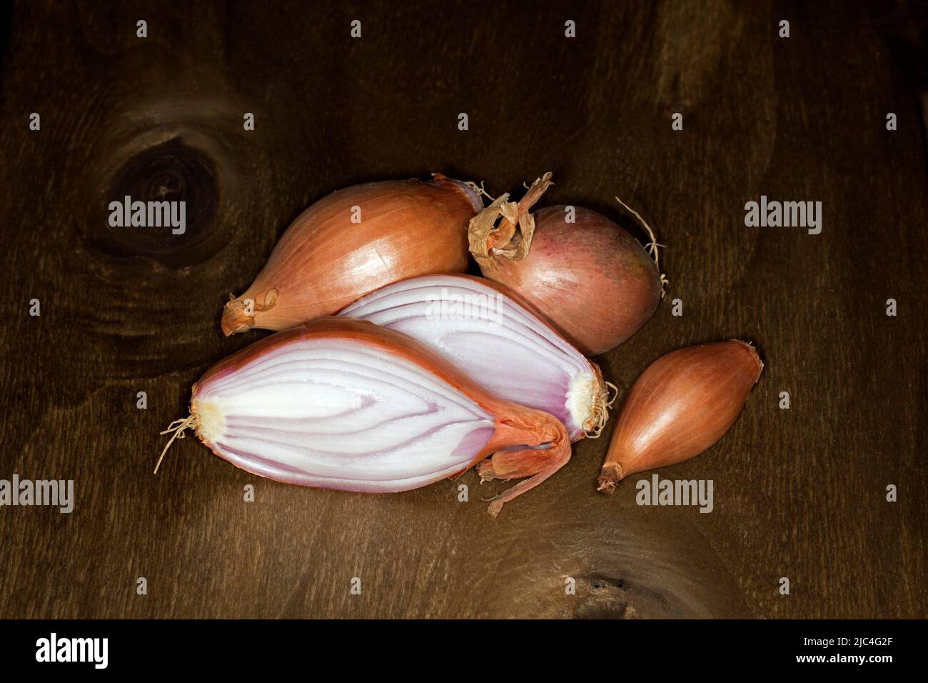 Half-baked common onion (Allium cepa var. aggregatum), on a wooden ...