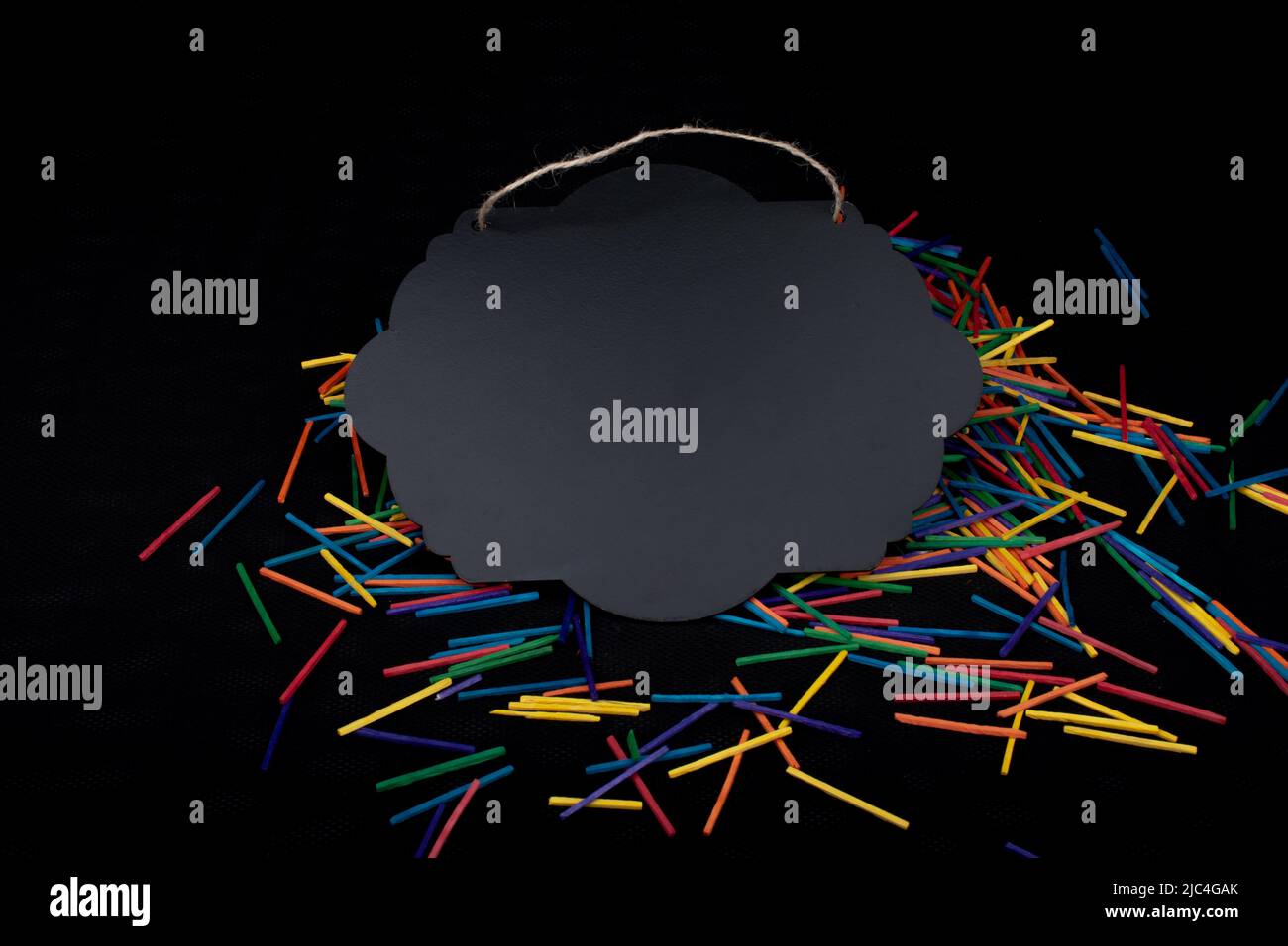 Black speech bubble shaped notice board on colorful sticks on black ...