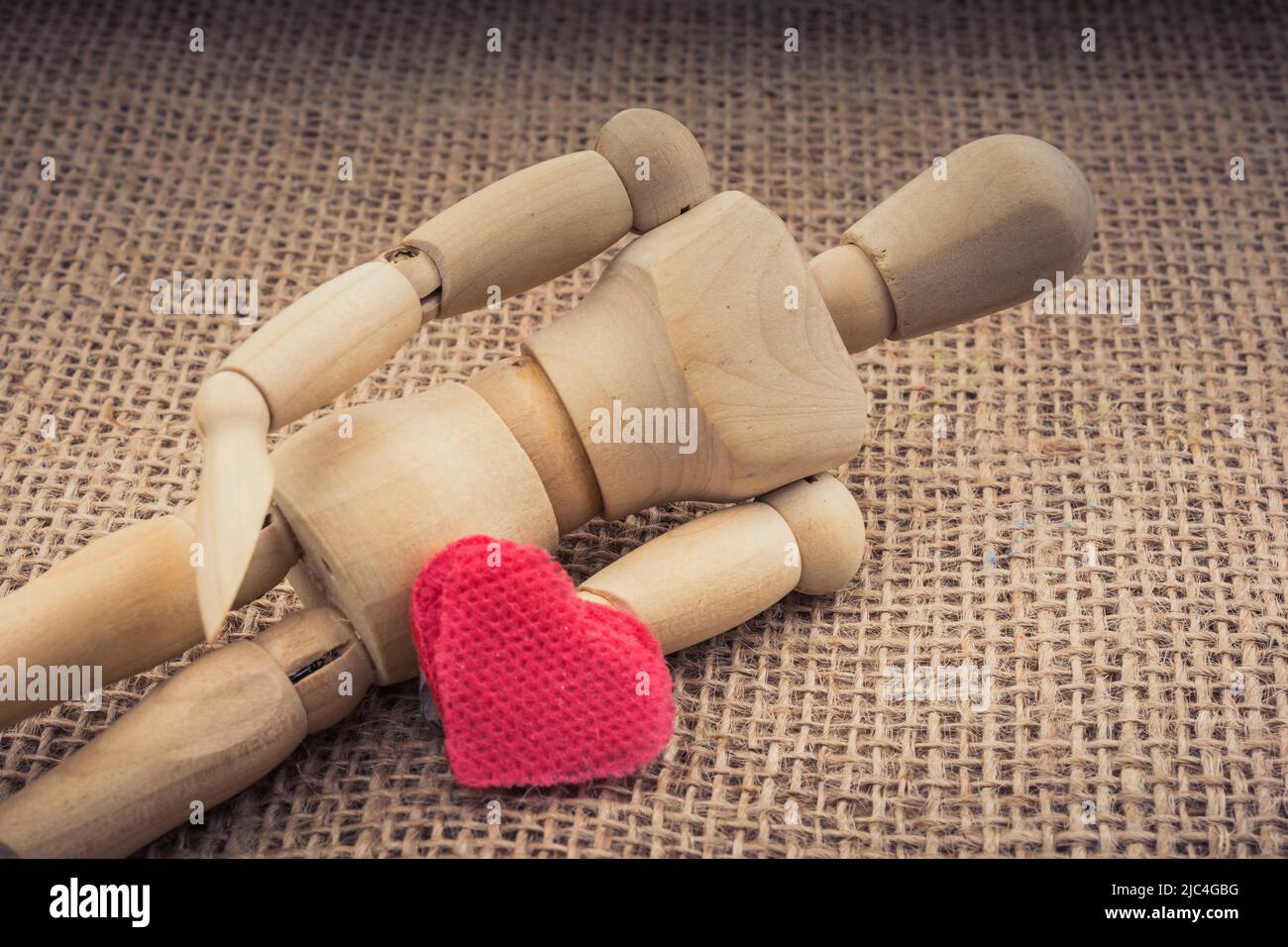 Heart shaped object in the hand of a wooden man toy Stock Photo - Alamy