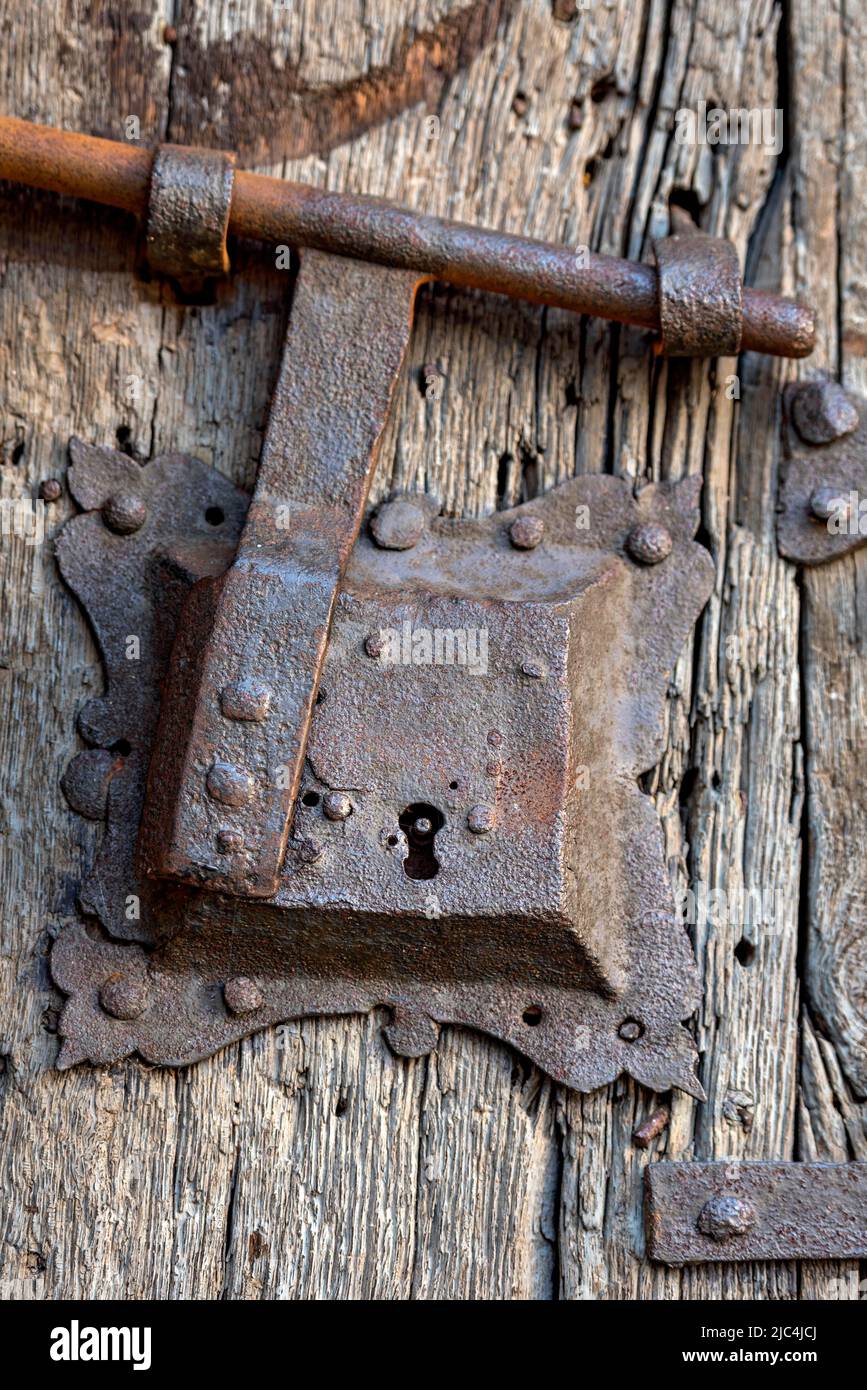 Rusty lap and bolt, weathered wooden door, entrance to historic dungeon ...