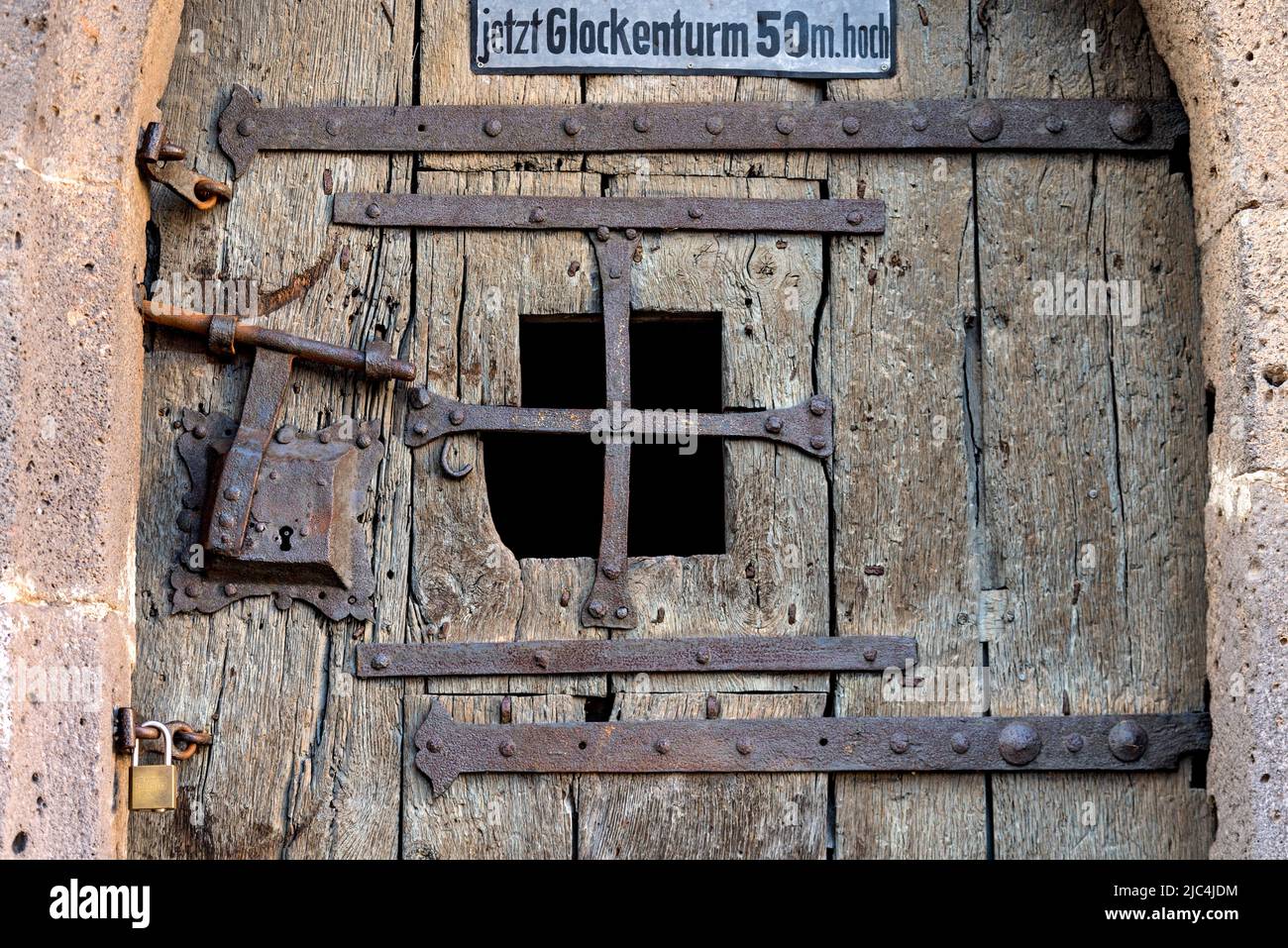 Rusty lap, bolts, bars and fittings, weathered wooden door, entrance to ...