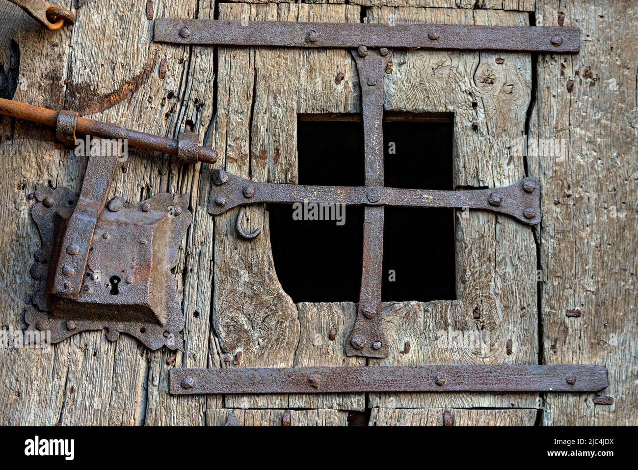 Rusty lap, bolts, bars and fittings, weathered wooden door, entrance to ...