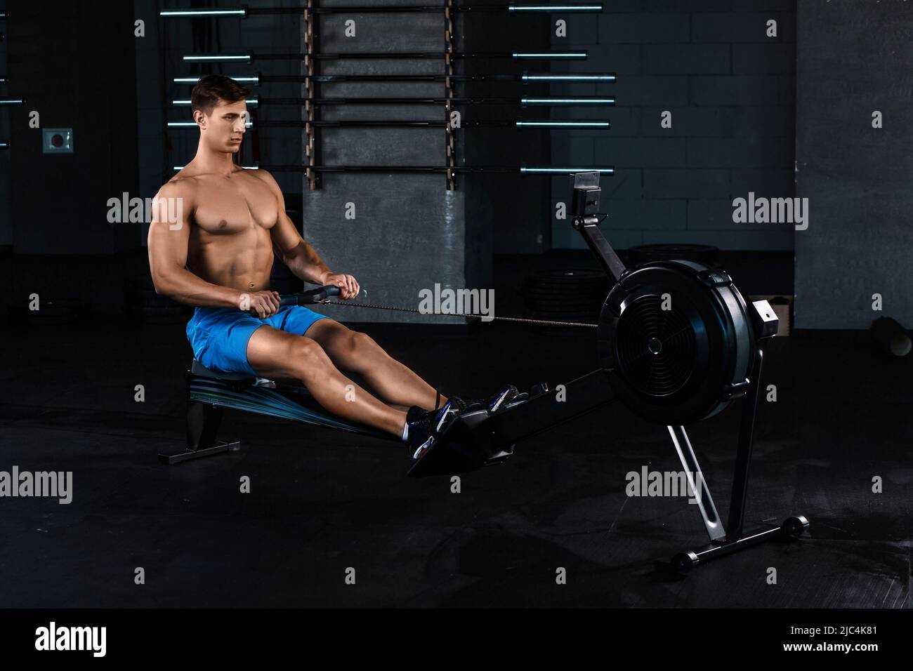 Muscular man doing exercise for legs in the gym Stock Photo - Alamy