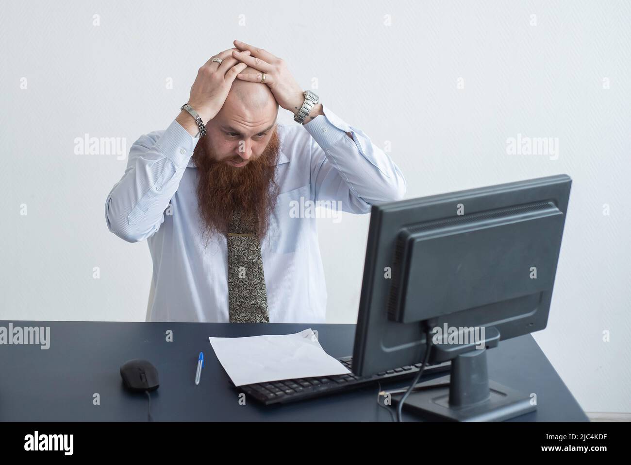 Problems for the office worker. A bald man in a white shirt sits at a ...