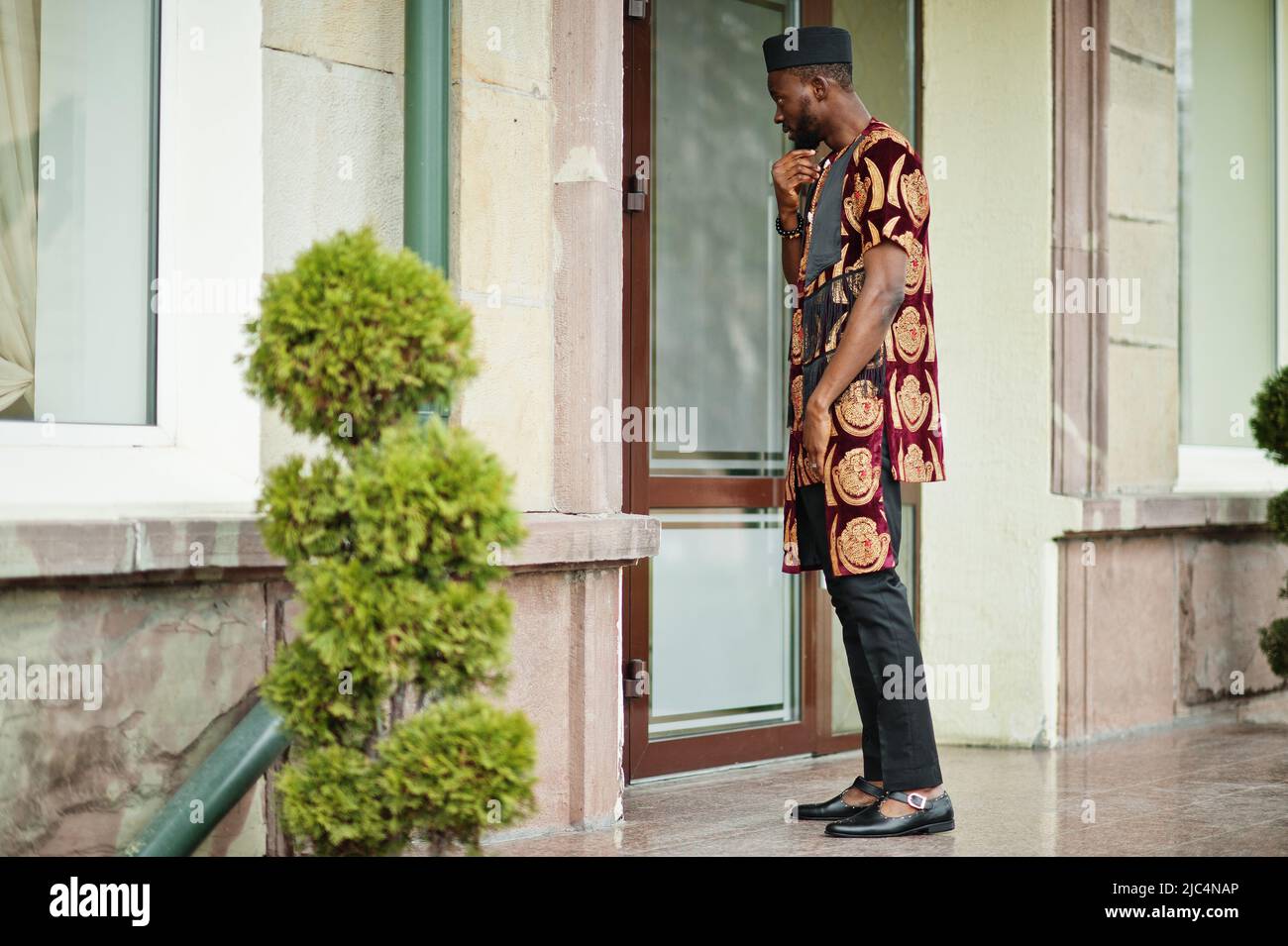 African stylish and handsome man in traditional outfit and black cap ...