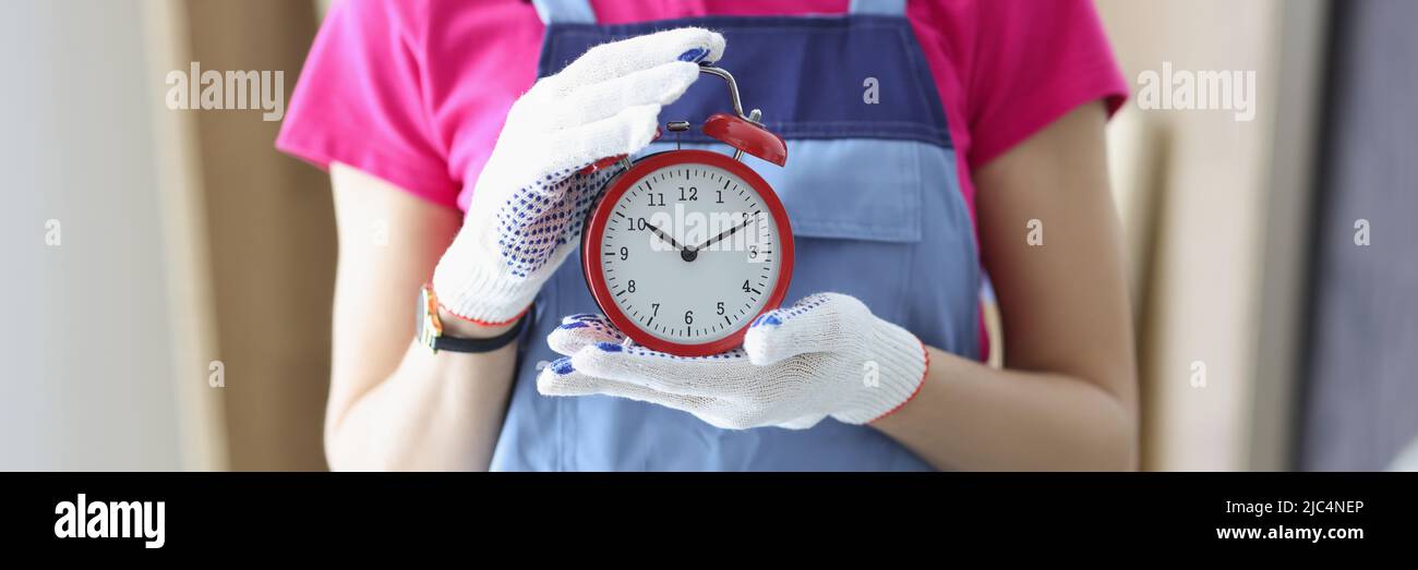 Woman worker in uniform holding red clock reminder to finish work on ...