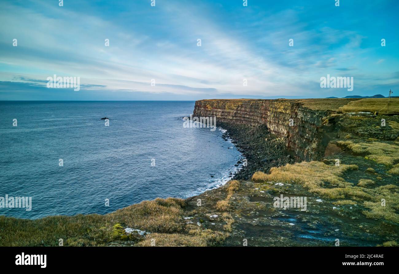 Steep cliffs with red seams in Iceland Stock Photo - Alamy