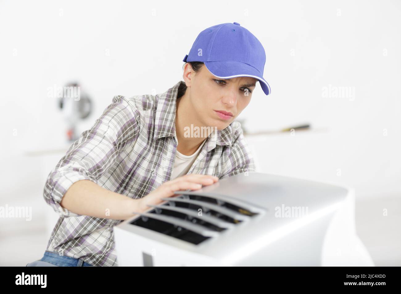 portrait of a woman fixing the air conditioning Stock Photo - Alamy