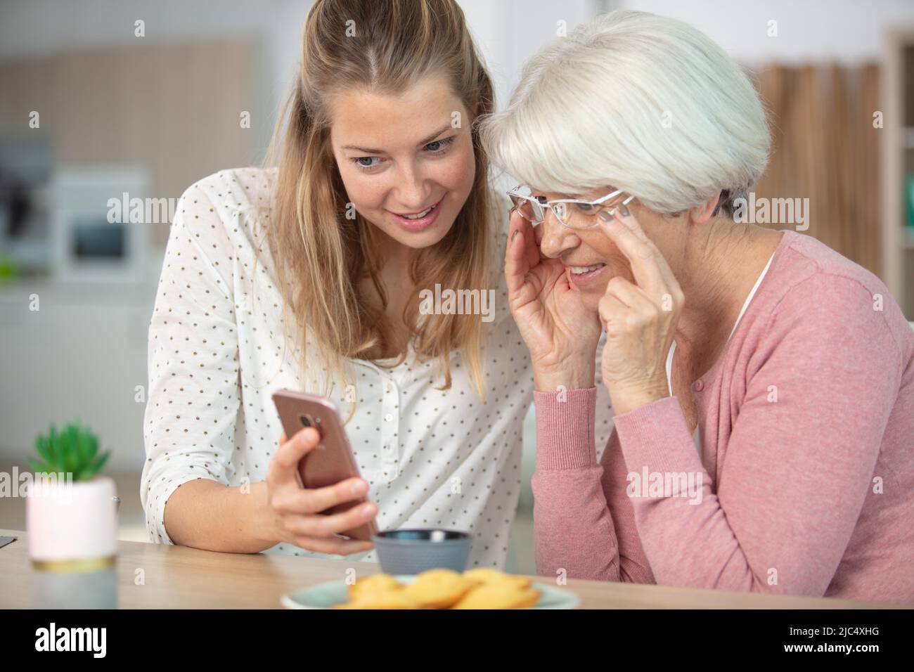 showing senior mum how to use the mobile phone Stock Photo - Alamy