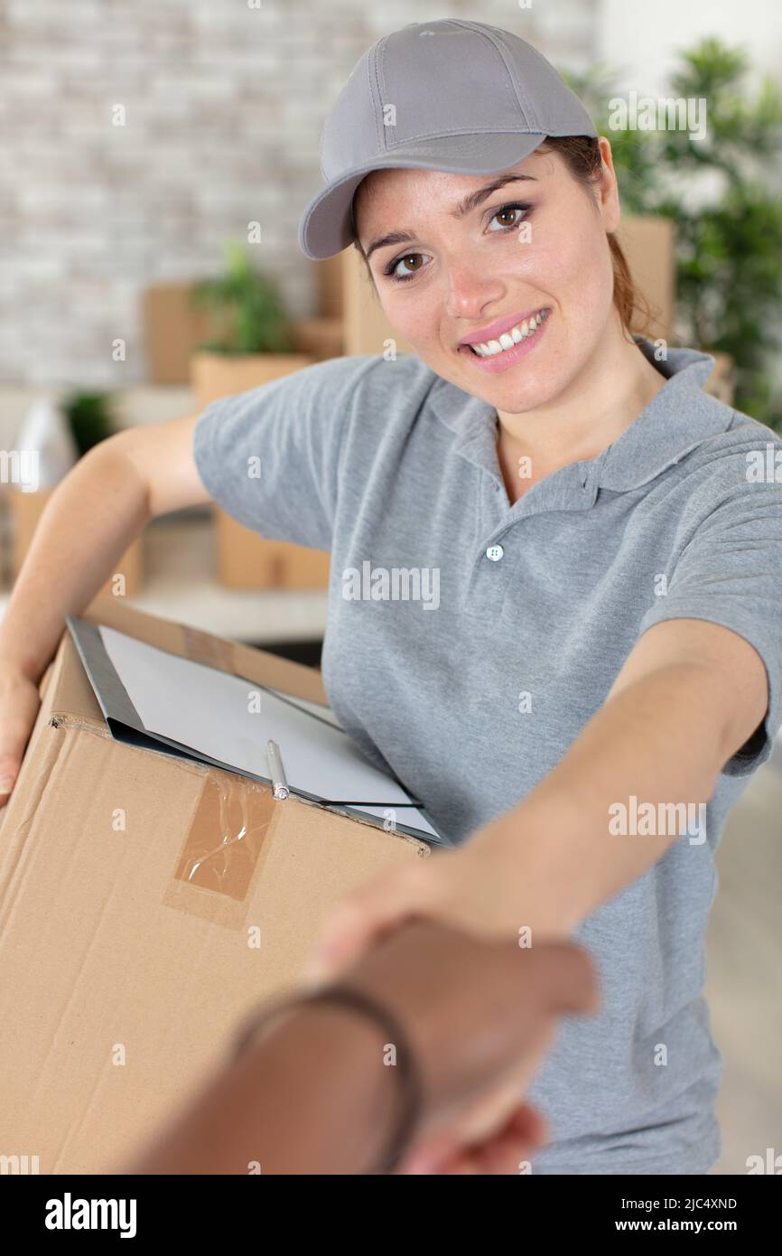 female delivery worker shaking hands with customer Stock Photo - Alamy