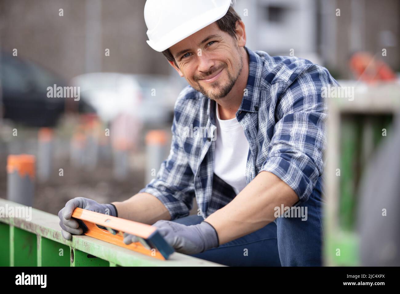 male construction worker using spirit level on site Stock Photo - Alamy