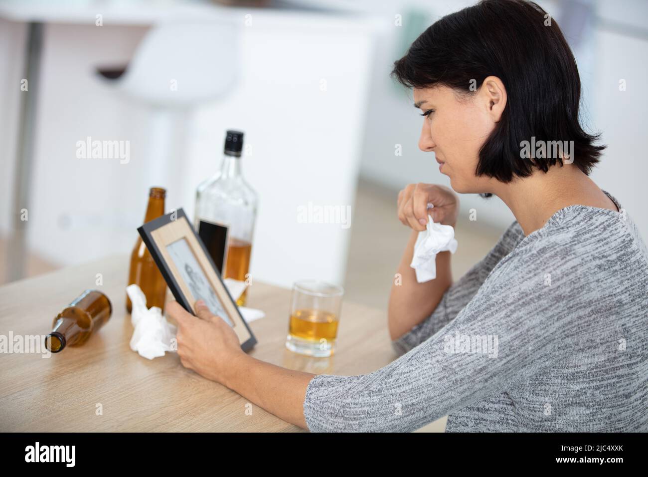 inebriated tearful woman looking at photograph Stock Photo - Alamy