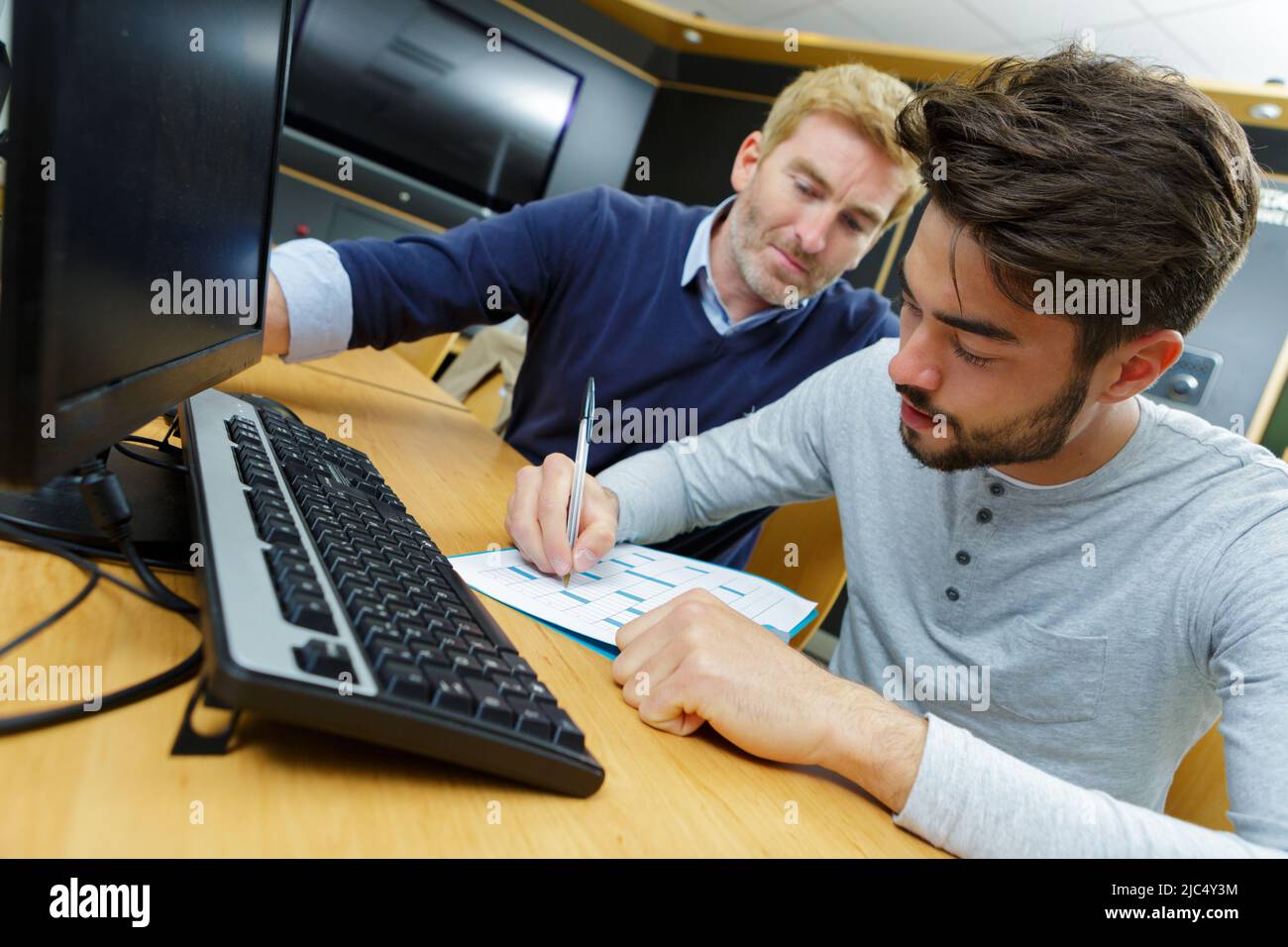 man looking at notes his younger colleague makes on chart Stock Photo ...