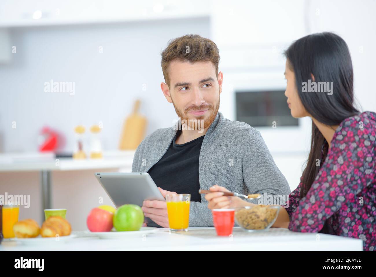 Using tablet computer whilst eating breakfast Stock Photo - Alamy