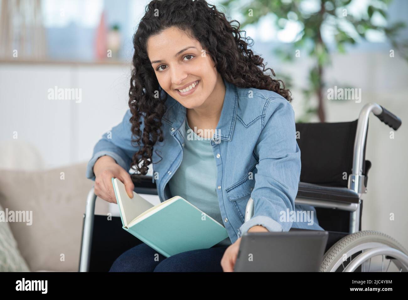 young disabled woman in wheelchair using a book Stock Photo - Alamy