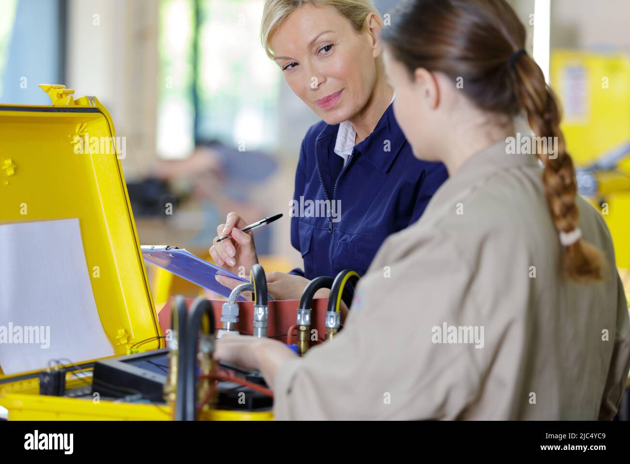 supervisor watching female mechanic using equipment Stock Photo - Alamy