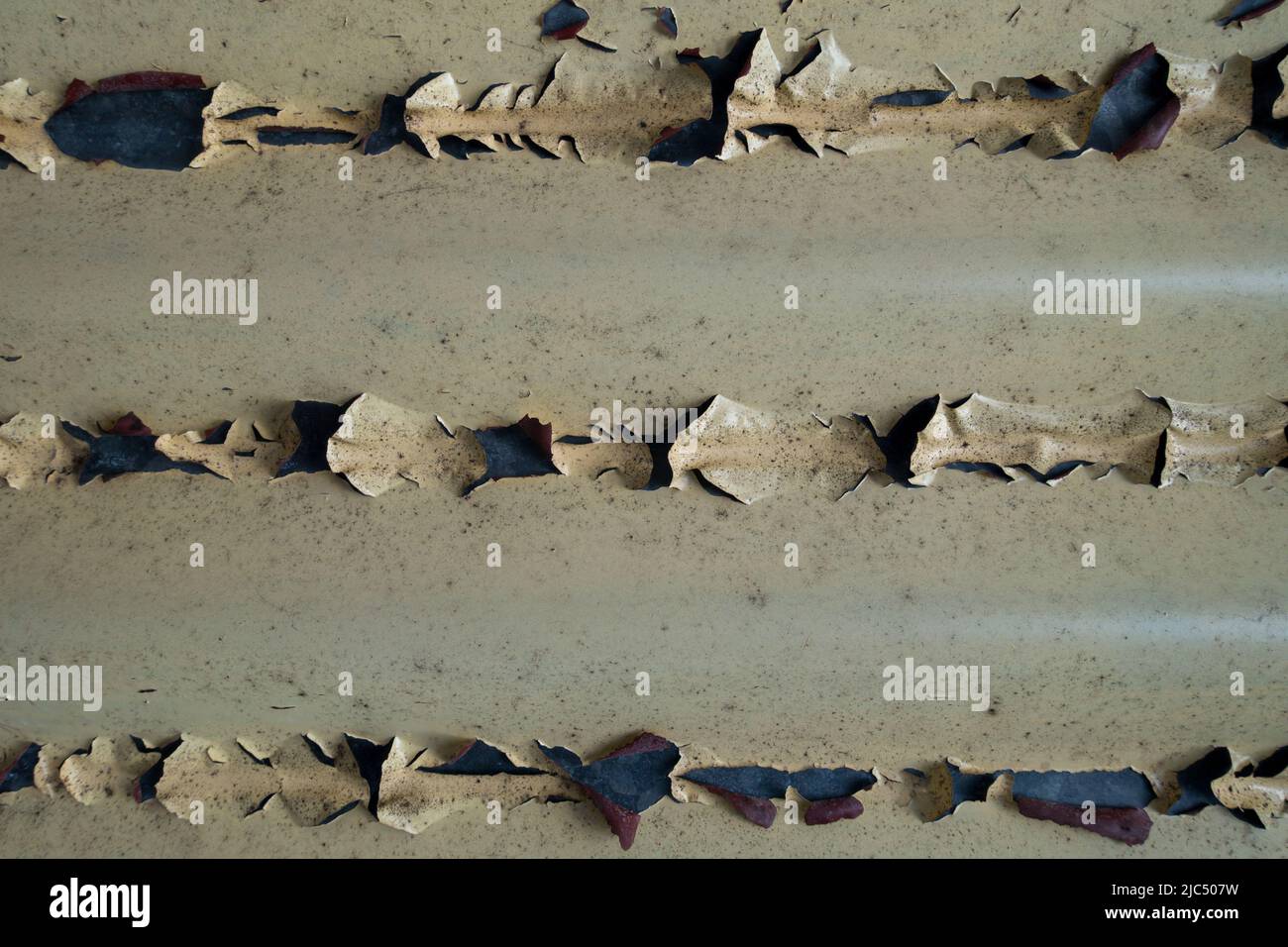 A close-up shot of paint coming off in peeled form from a metal sheet ...
