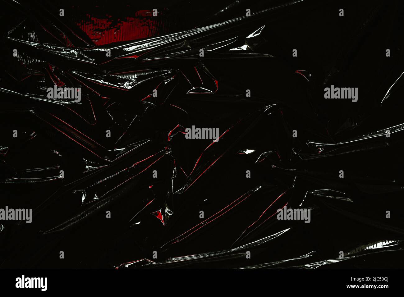 Transparent plastic wrap on black background. Crumpled wrinkled plastic ...