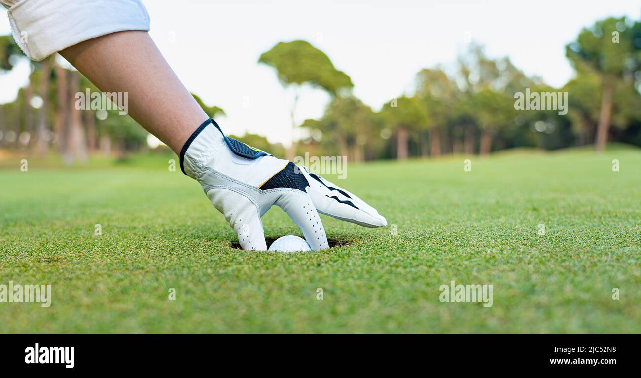 A golfer pulls a golf ball out of the hole. Ball deep Stock Photo - Alamy
