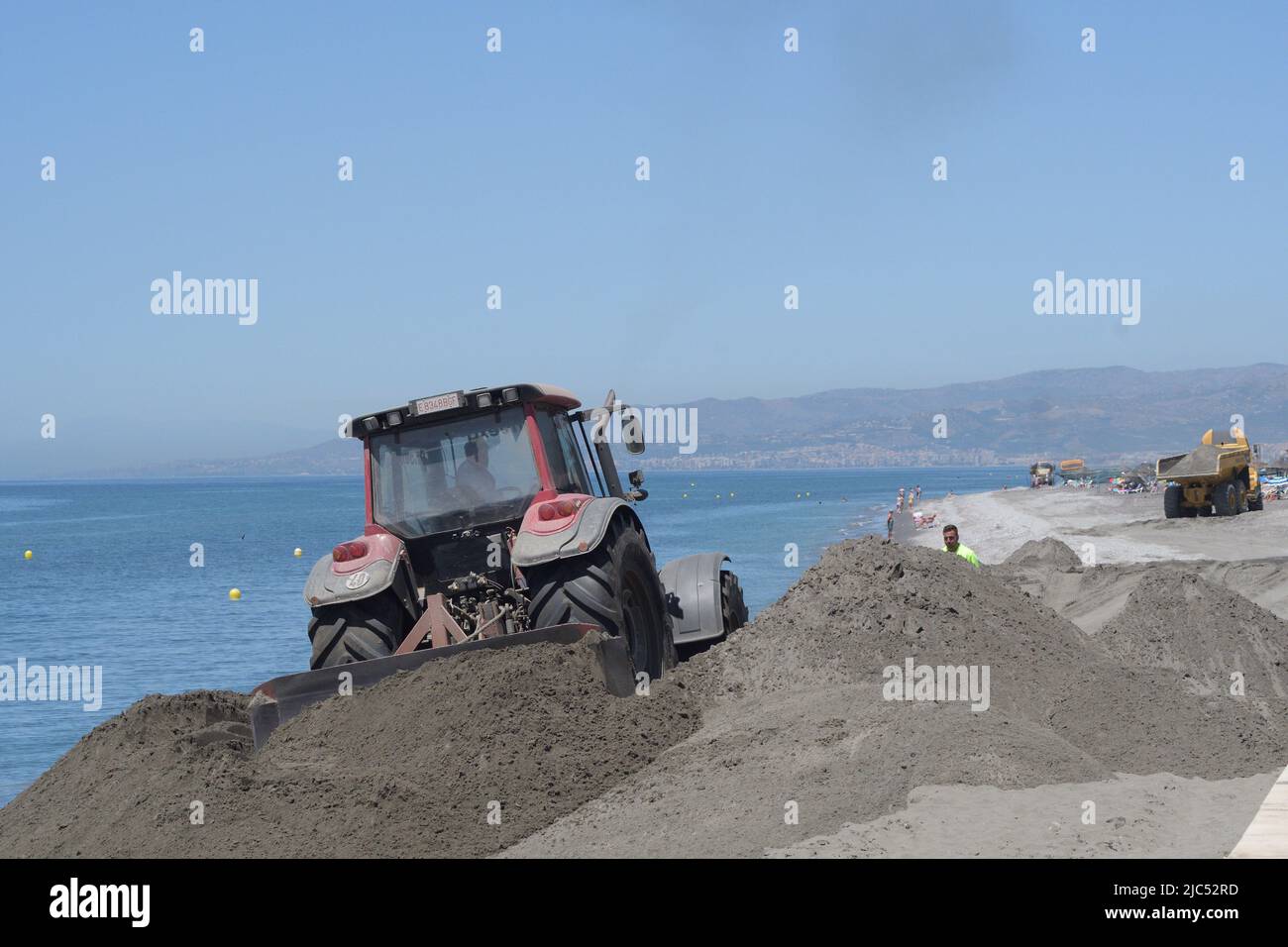 Tractor machine nivelating sand in works of regeneration of beaches ...