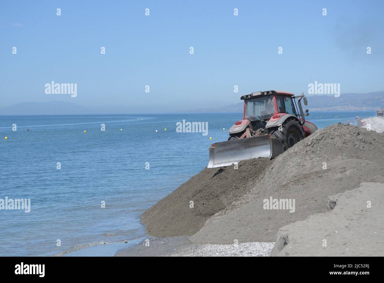 Tractor depositing sand in works of regeneration of beaches Stock Photo ...