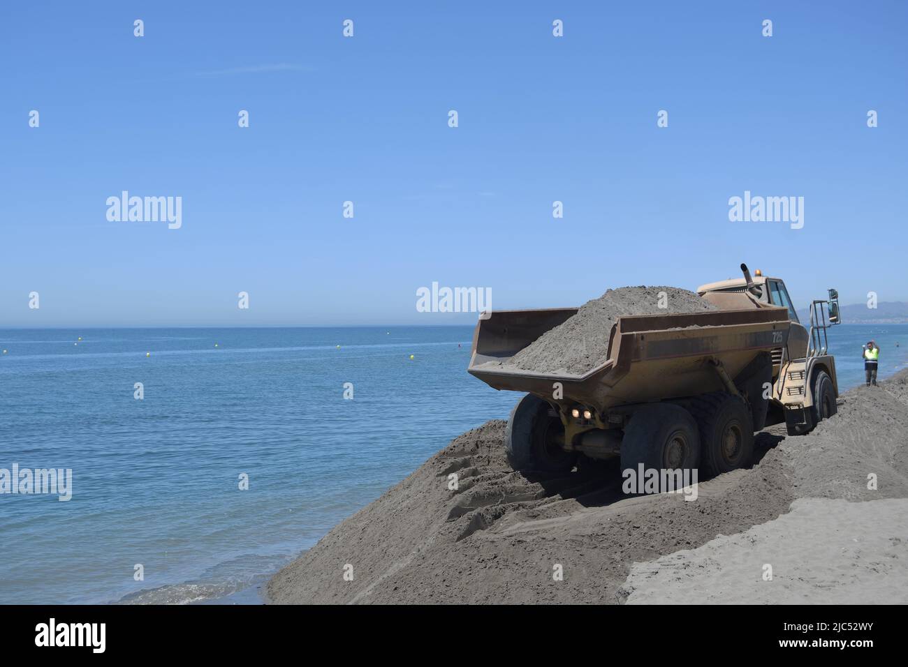 Truck machine unloading sand together a beach. Beaches generations ...