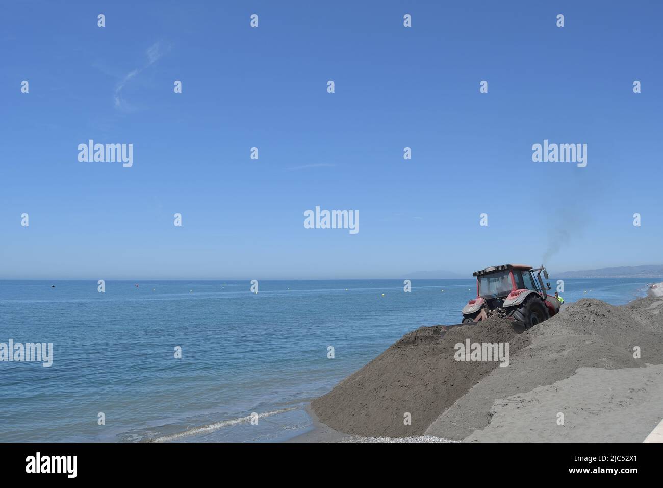 Tractor machine moving sand in works of regeneration of beaches Stock ...