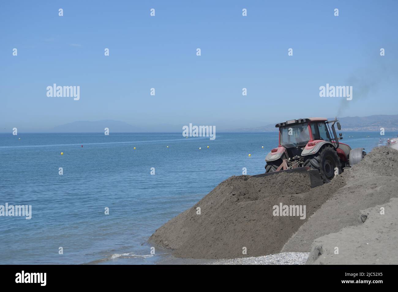 Tractor machine moving sand in works of regeneration of beaches Stock ...