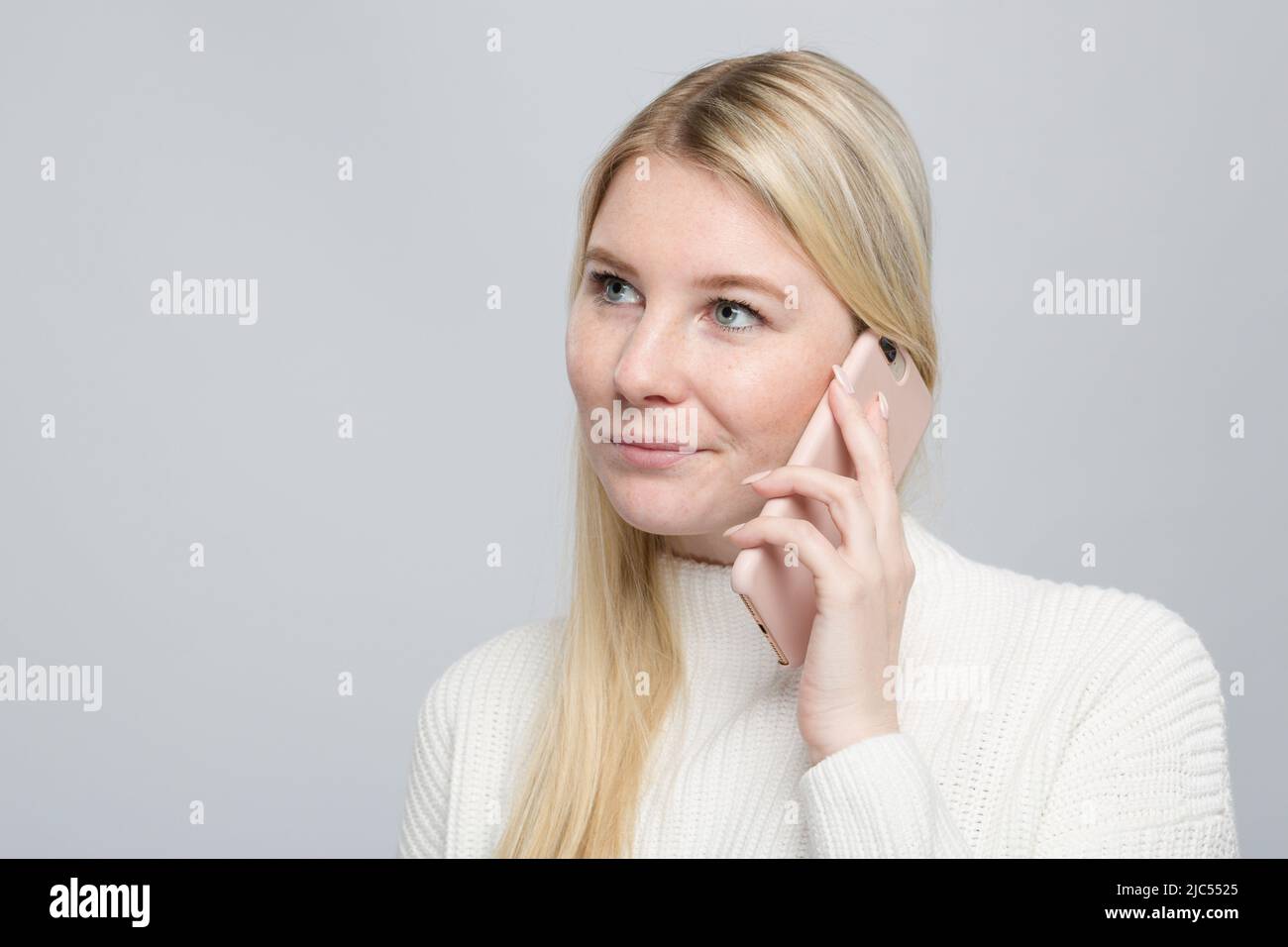 blonde woman is talking / listening on the mobile phone Stock Photo - Alamy