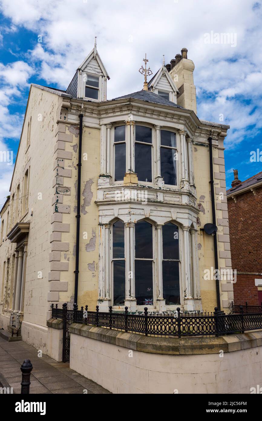 A Victorian house on the seafront with peeling paintwork at the ...