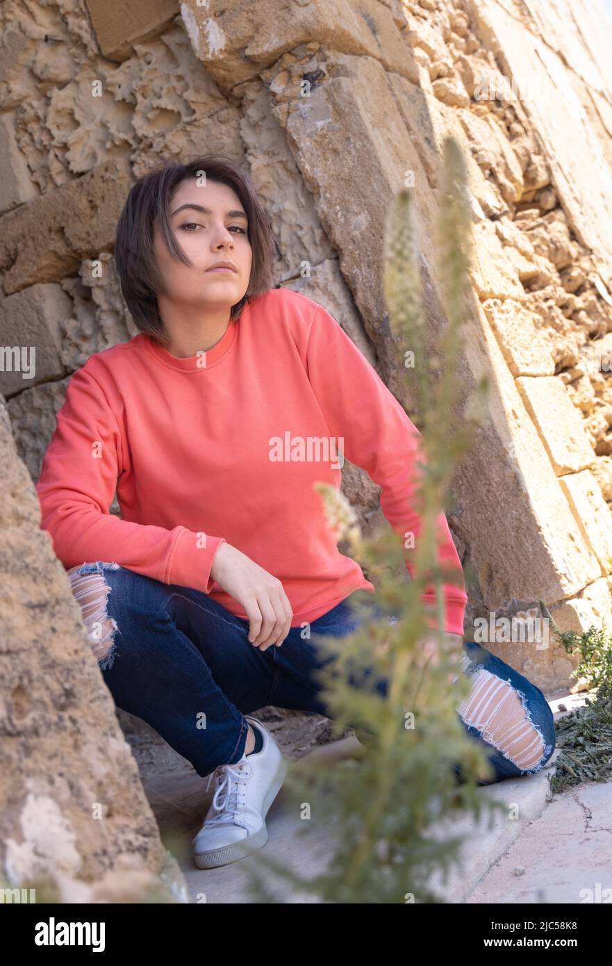 Teen girl wearing pink long sleeve shirt looking into camera. Mockup ...