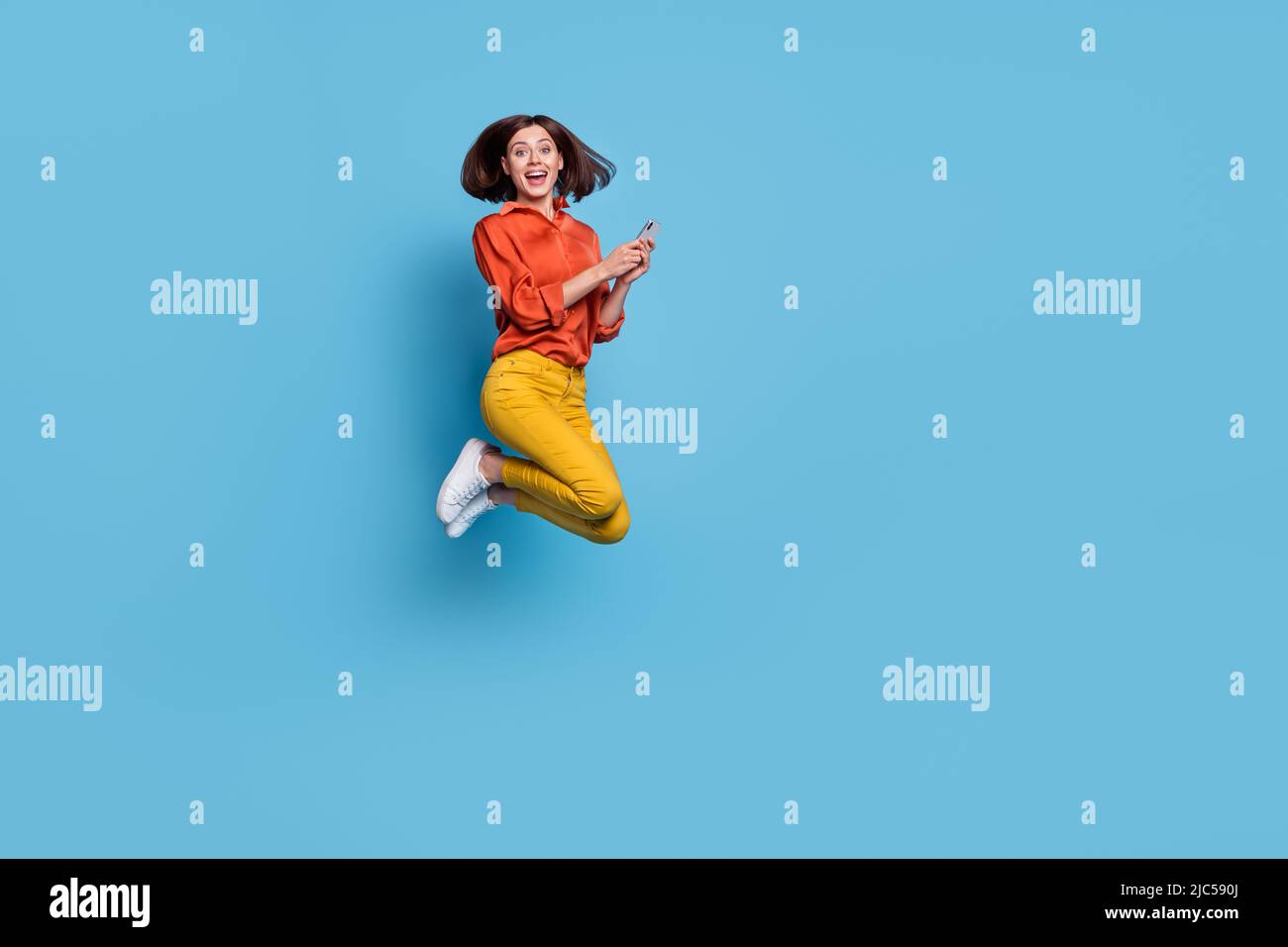 Full body profile side photo of young woman jump use mobile like repost ...