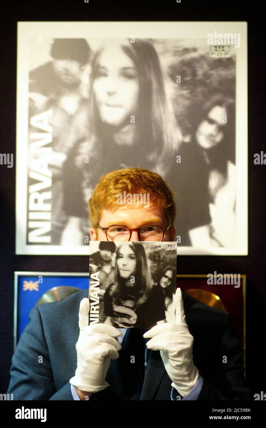 A gallery assistant holds Nirvana: a limited edition US pressing of the ...