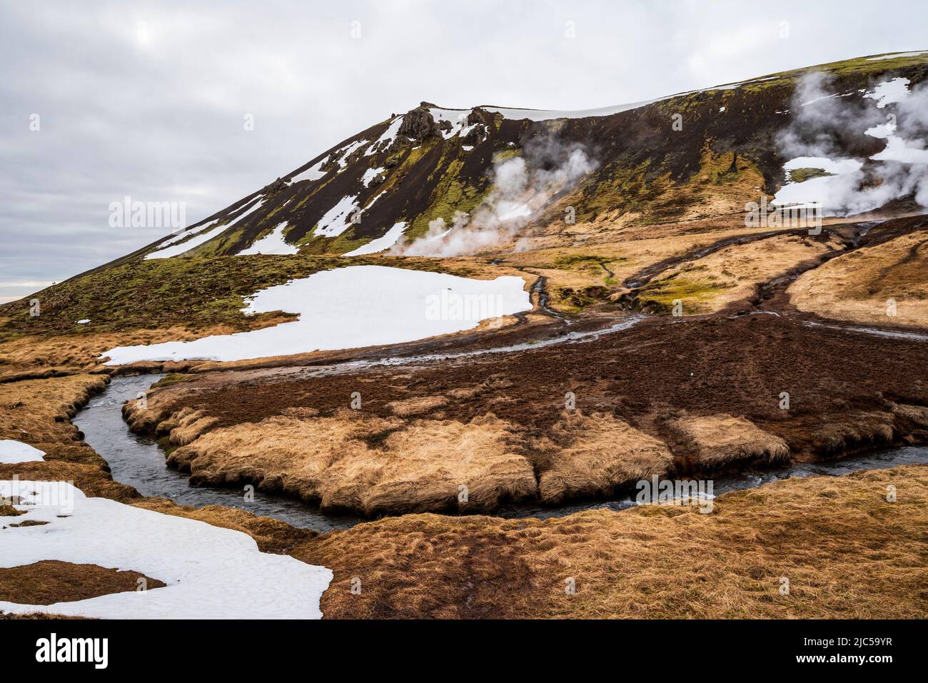 Steam rises above the hot springs in Reykjadalur valley, destination of ...