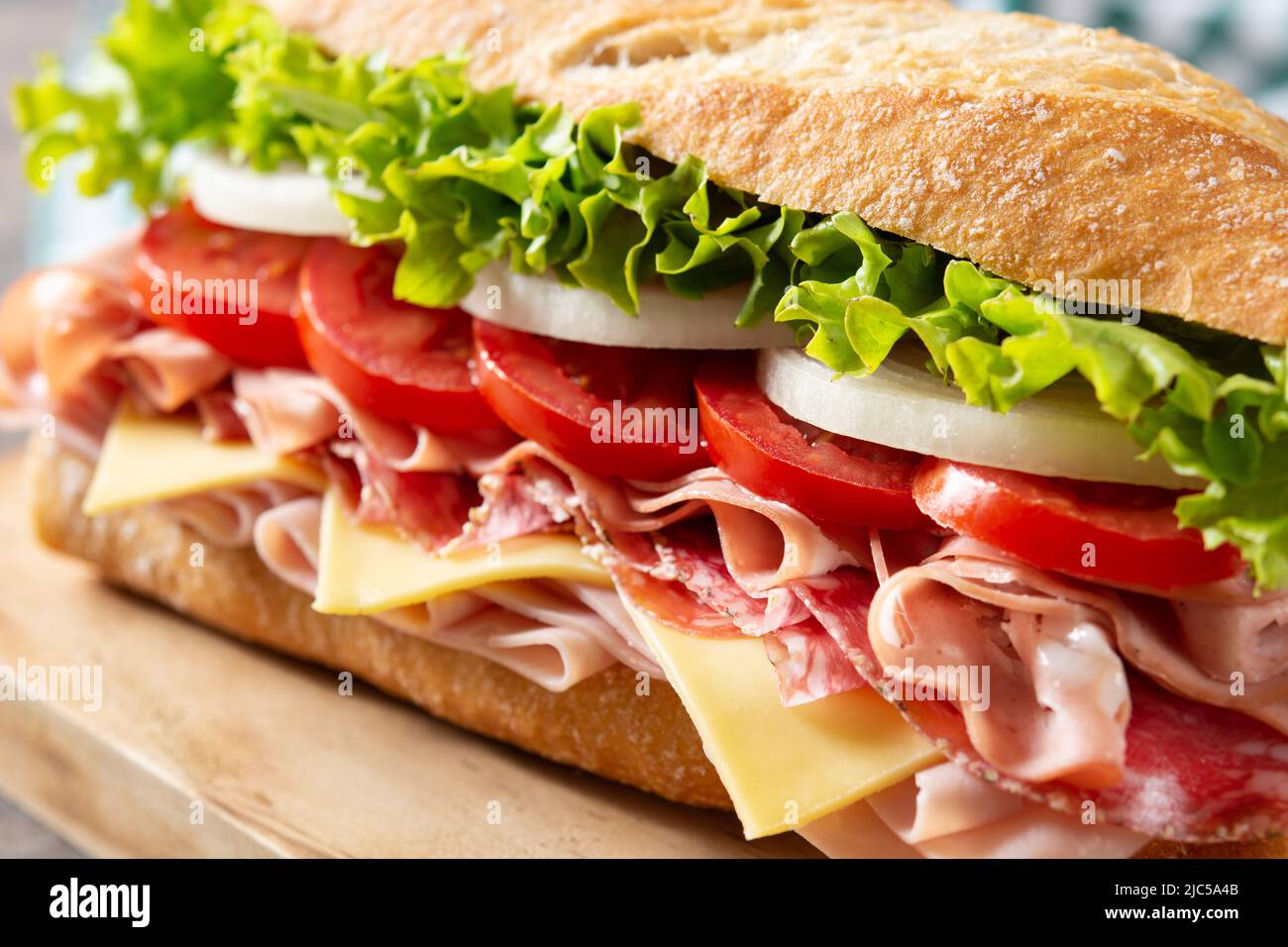 Submarine sandwich with ham, cheese, lettuce, tomatoes,onion ...