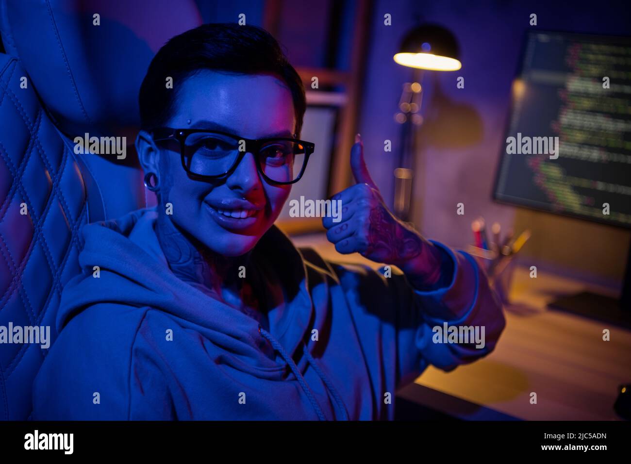Photo of busy confident programmer wear hoodie piercing glasses showing thumb up indoors ...