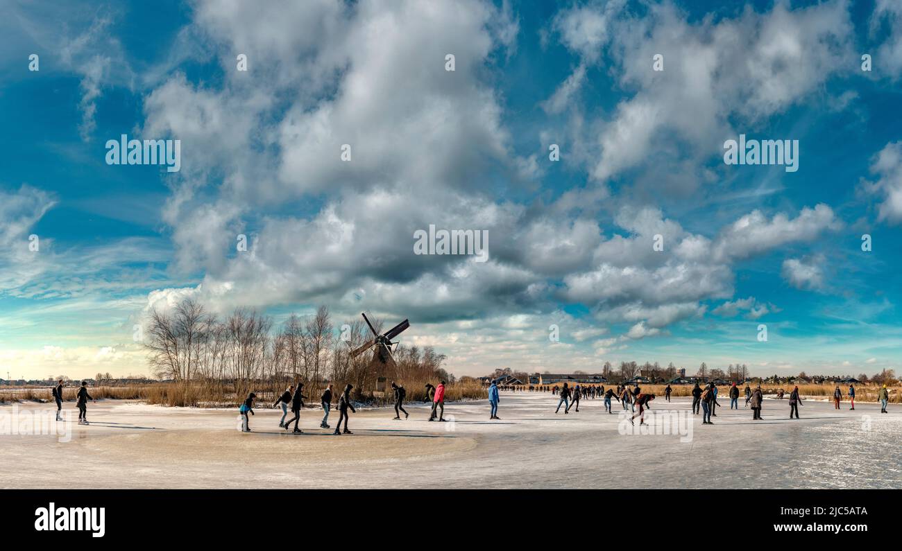 Scating on a frozen canal near a windmill *** Local Caption ...